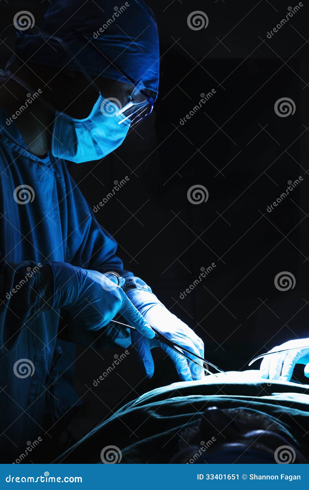 Surgeon Looking Down, Working, and Holding Surgical Equipment with ...