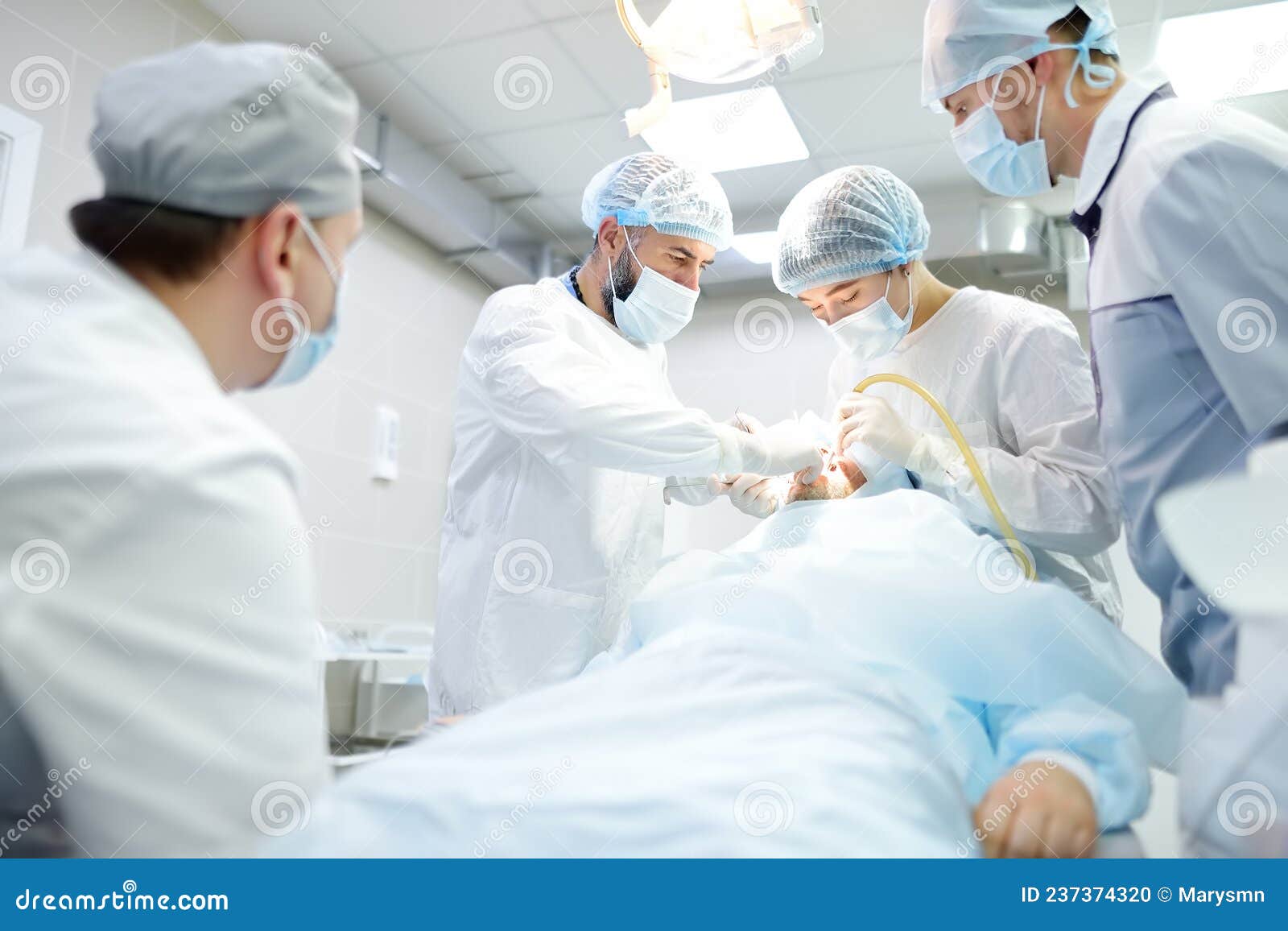 Surgeon and Nurse during a Dental Operation. Anesthetized Patient in ...