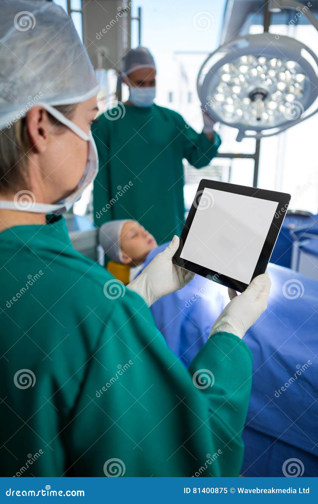 Surgeon Using Digital Tablet while Operating Patient Stock Image ...