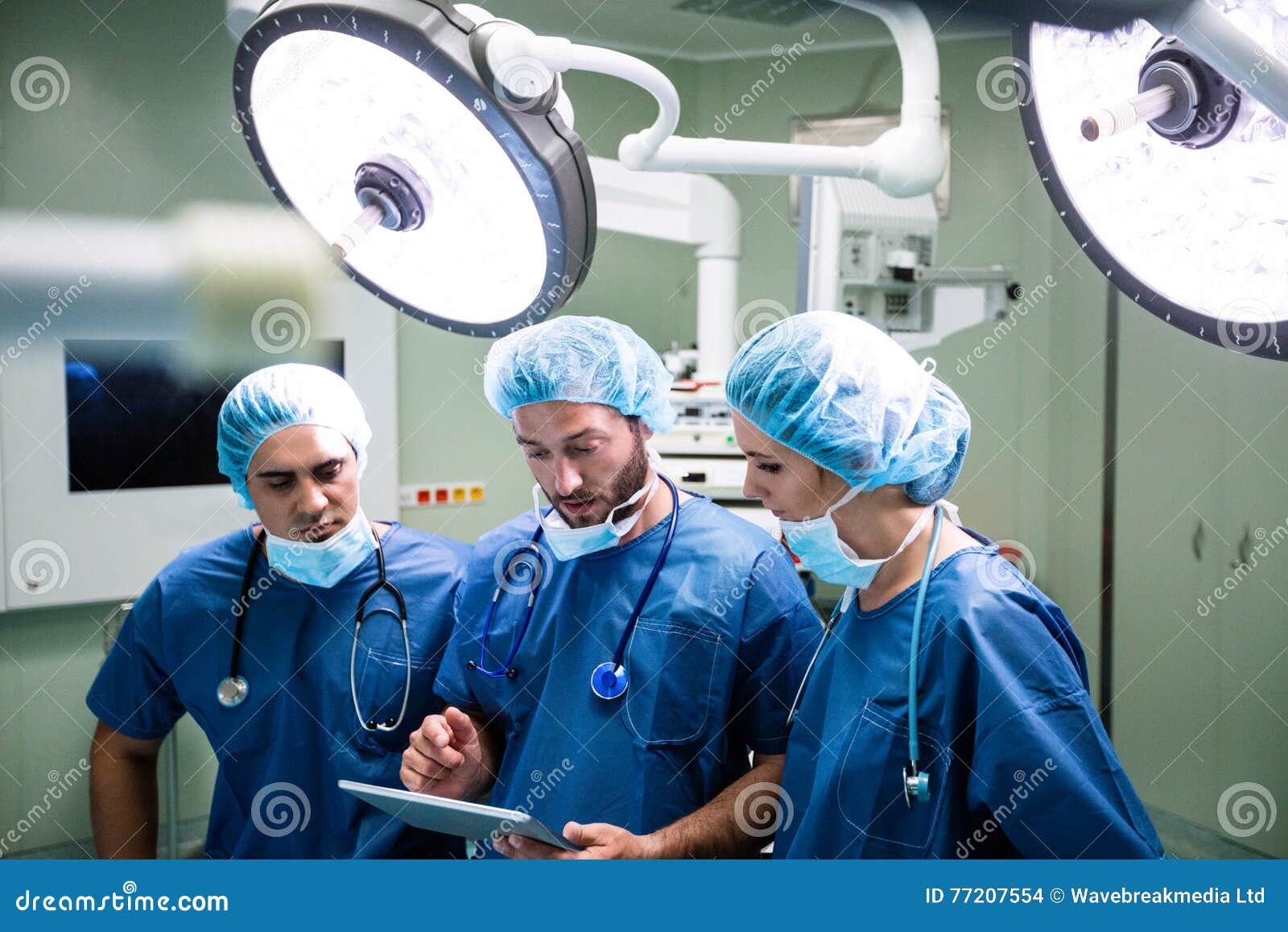 Surgeons Discussing Over Digital Tablet in Operation Room Stock Photo ...