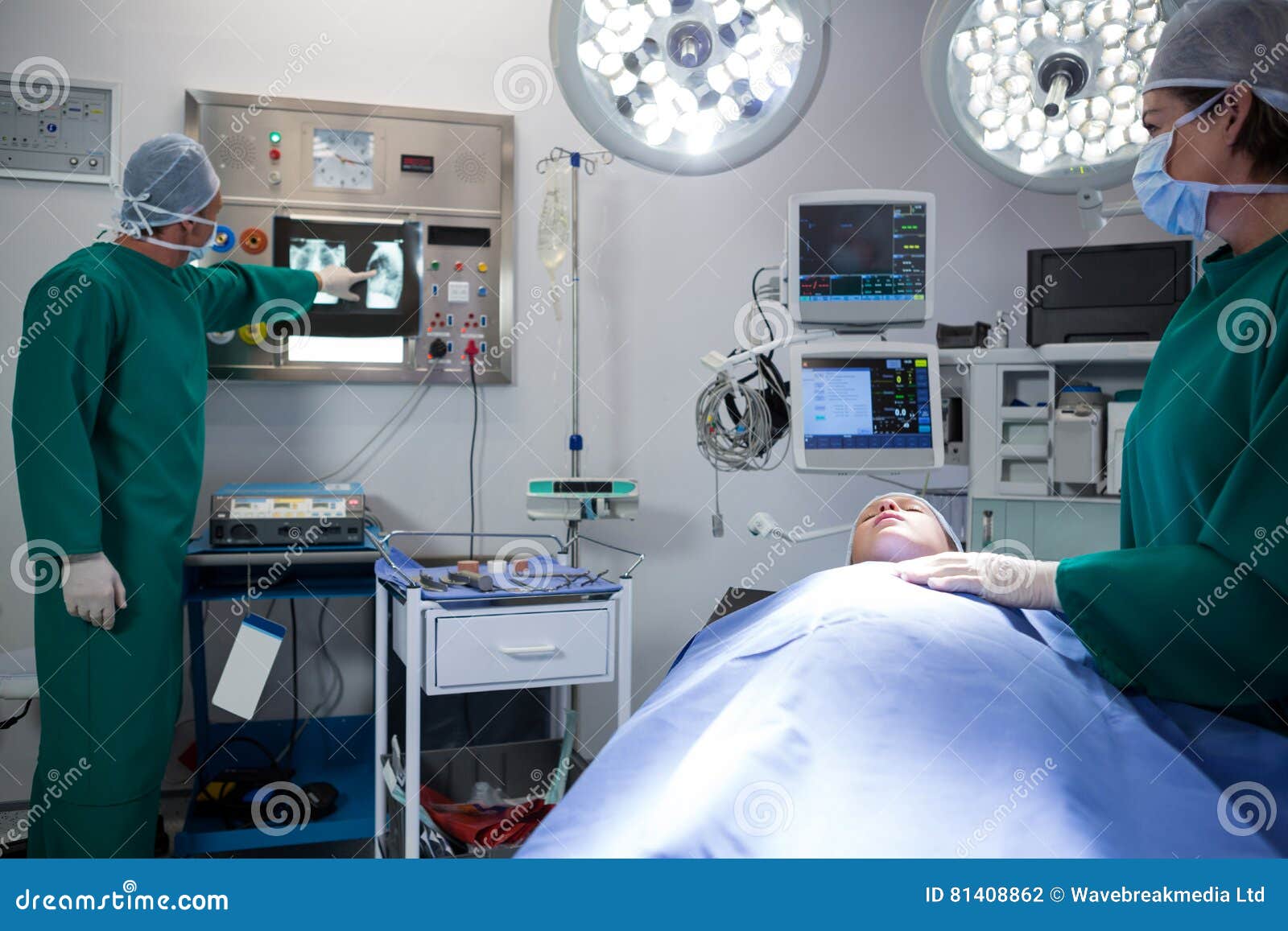 Surgeons Discussing X-ray while Operating Patient Stock Photo - Image ...