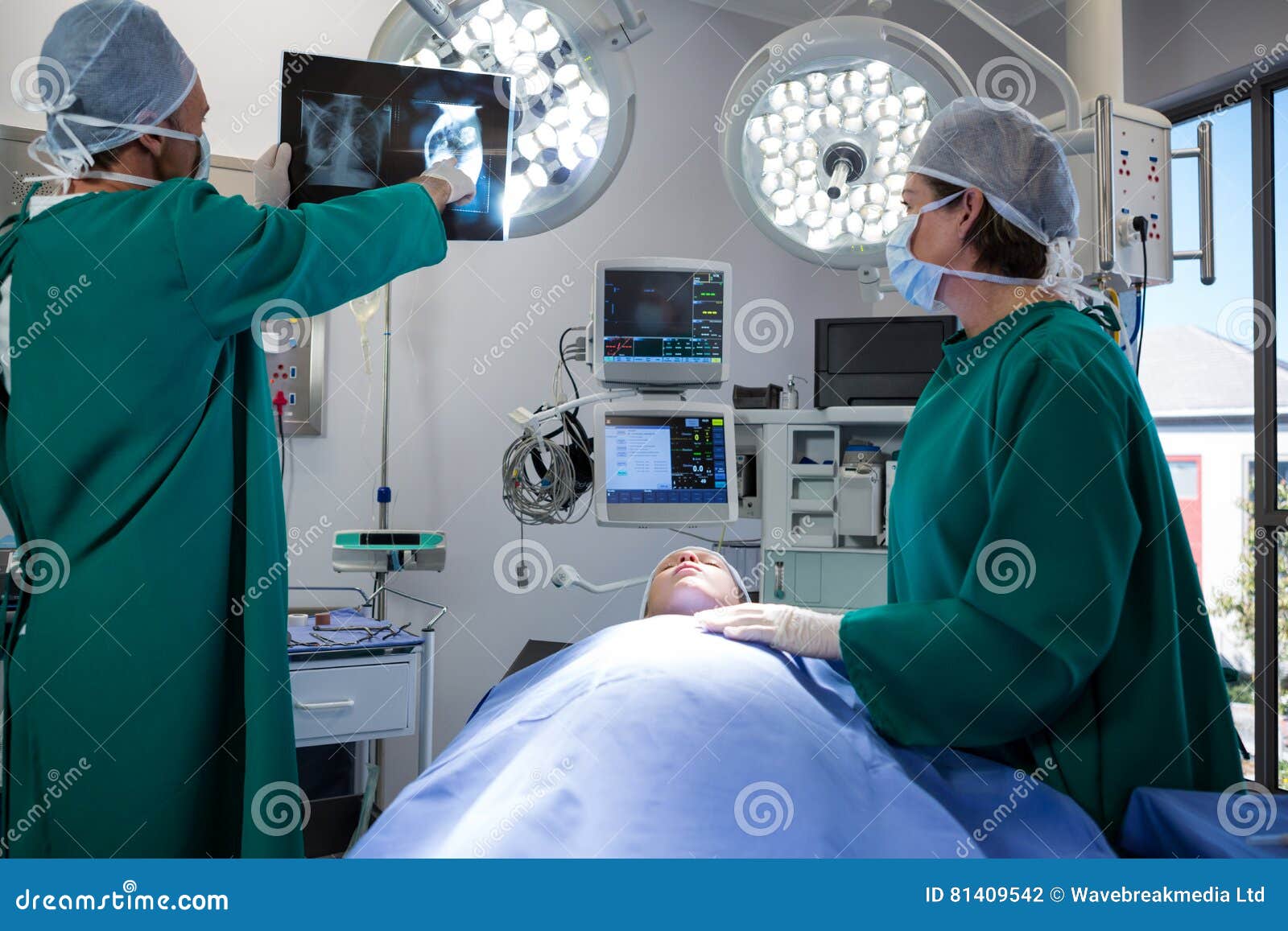 Surgeons Discussing X-ray while Operating Patient Stock Photo - Image ...