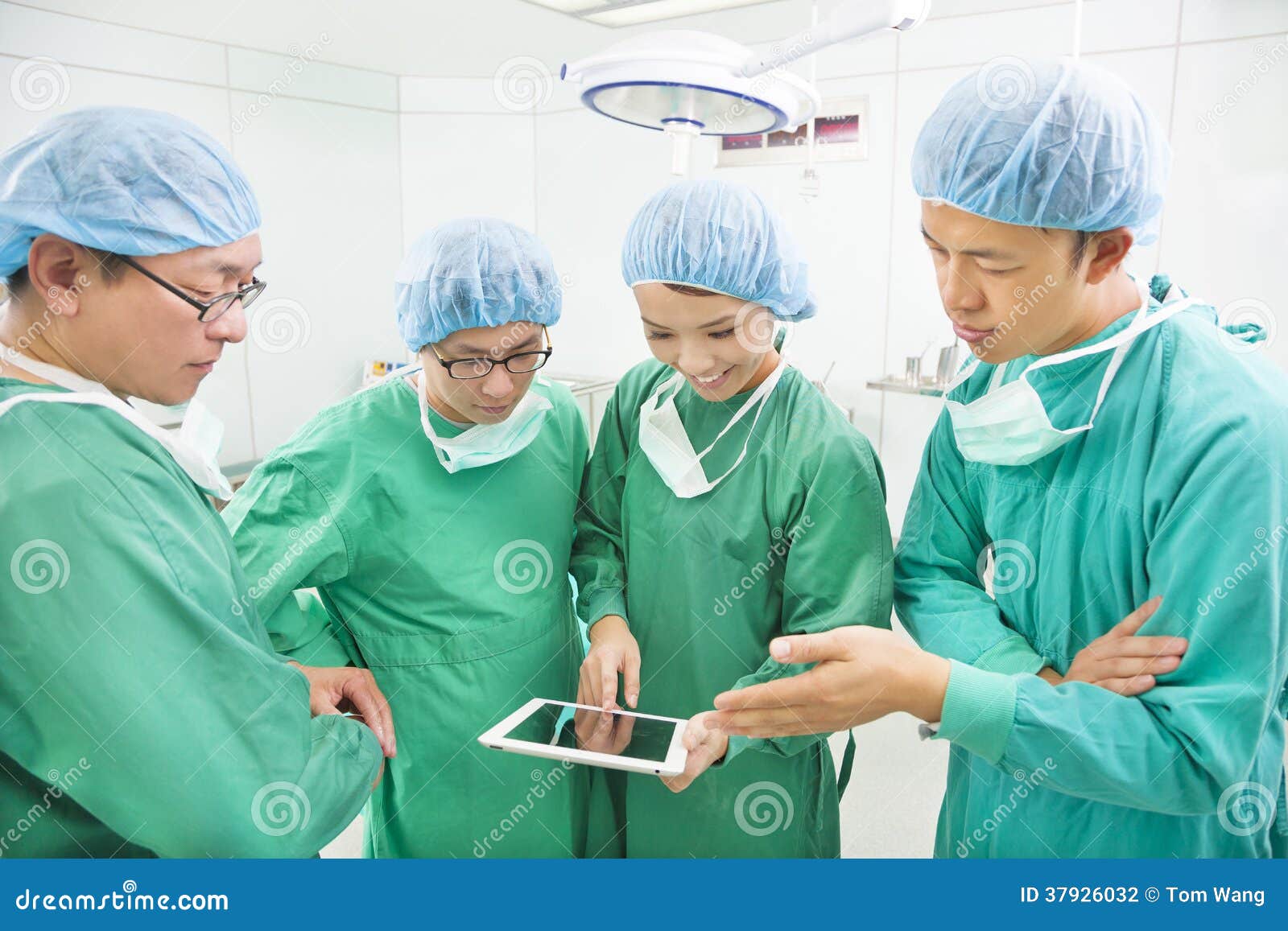 Surgeons Discussing with Tablet in Operation Room Stock Photo - Image ...