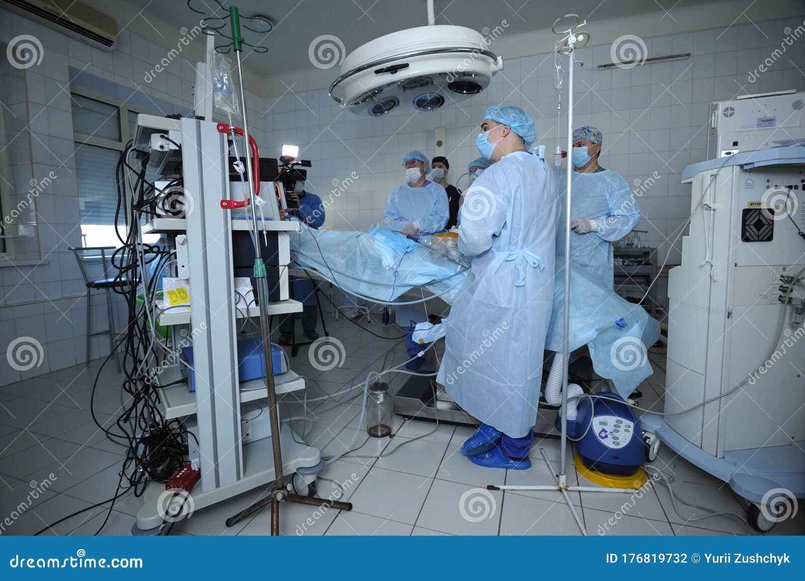 Surgeons in Face Masks Standing Around Patient Plate and Performing an ...