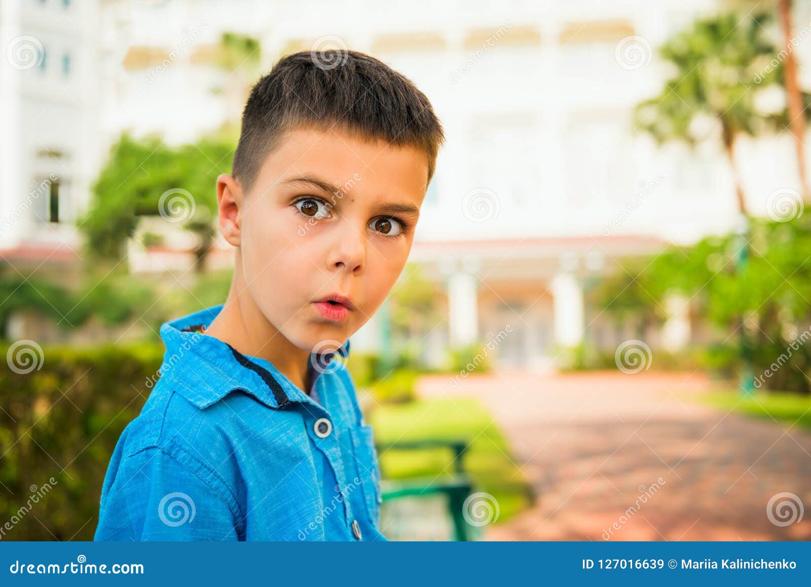 Surprised Boy In Blue Shirt On Background Of Light Building Royalty ...