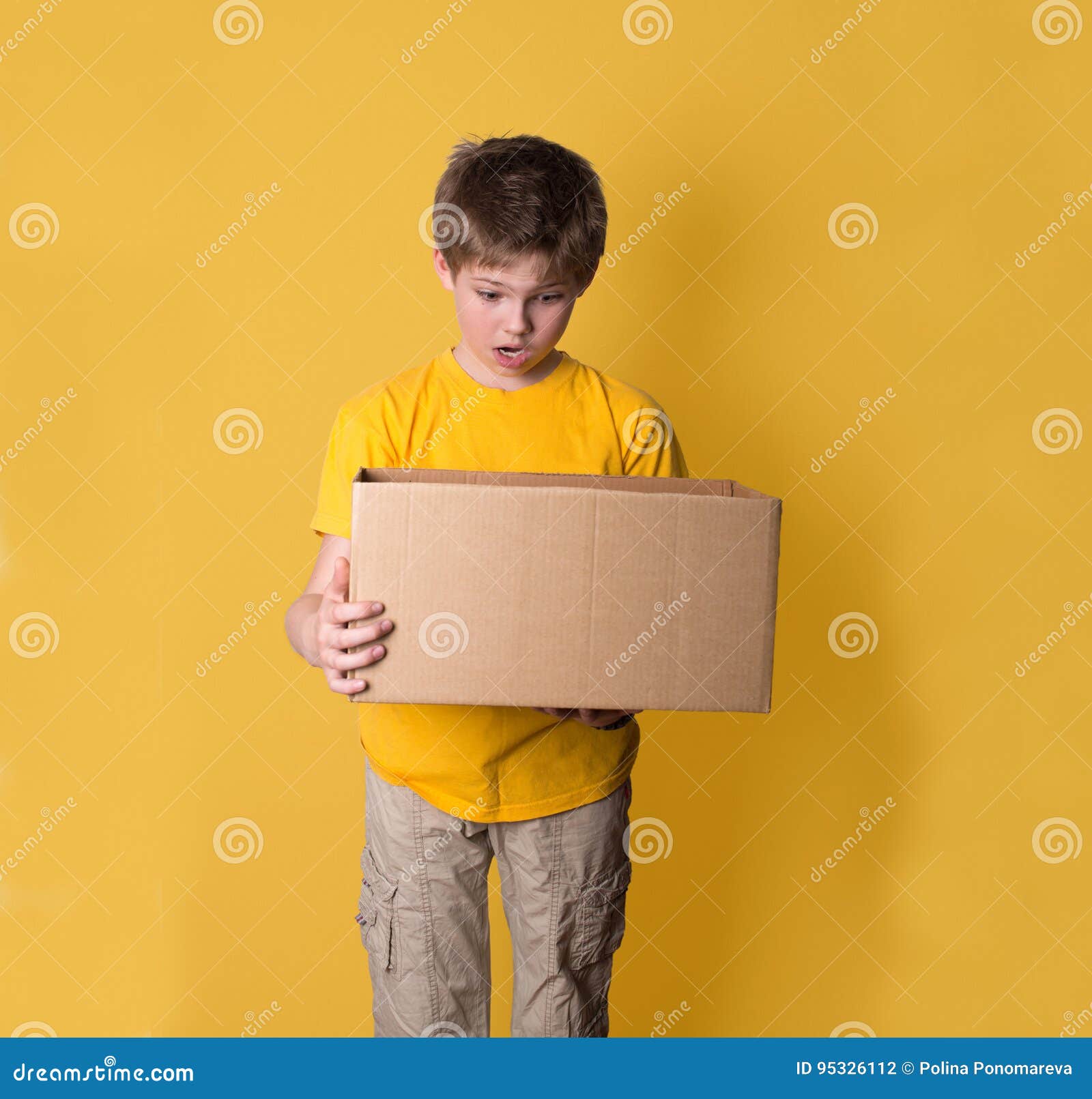 Surprised Boy Looking into the Box Isolated on Yellow Background Stock ...