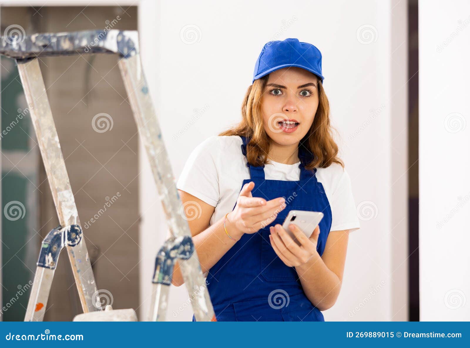 Surprised Construction Worker Using Smartphone in Apartment Stock Image ...