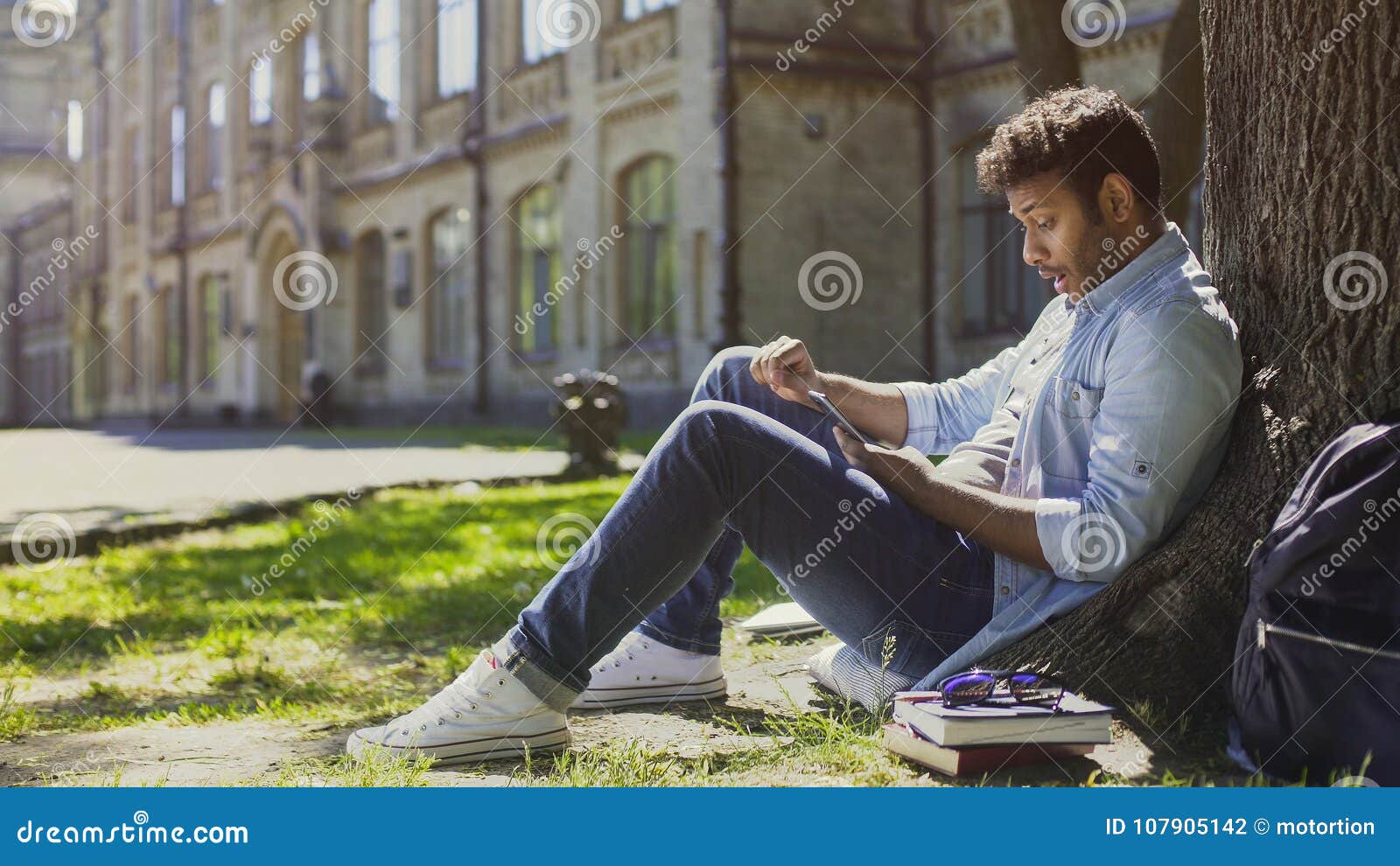 Surprised Guy Sitting Under Tree, Using Mobile Phone, Reacting To ...