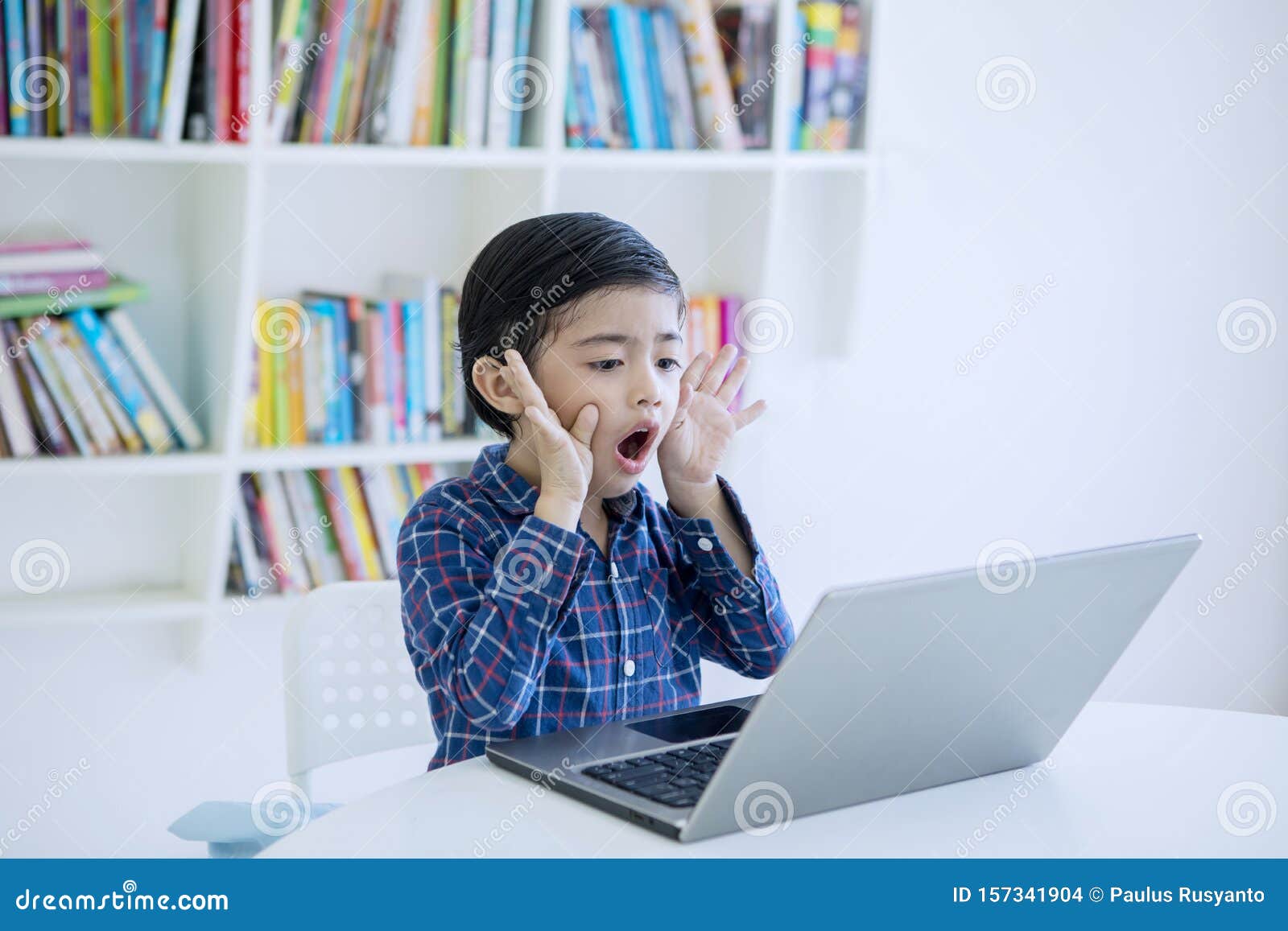 Surprised Little Boy Using a Laptop in the Library Stock Photo - Image ...