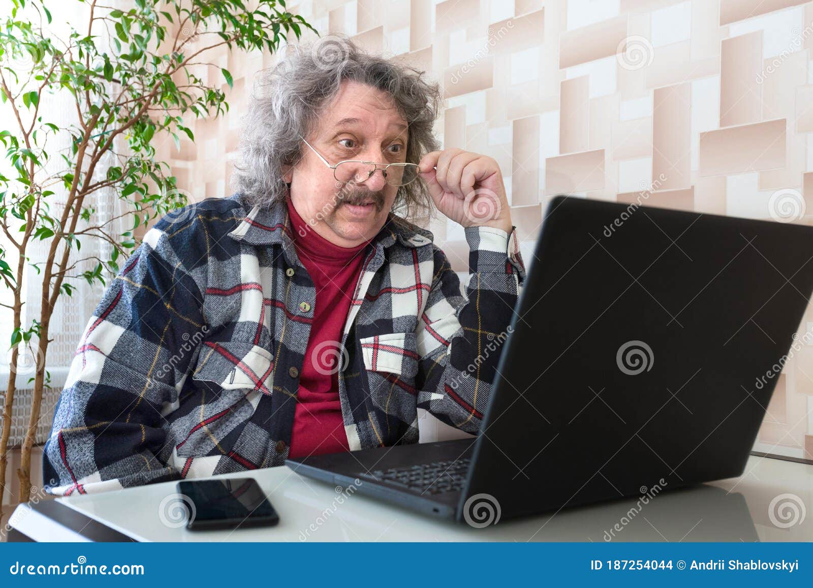 A Surprised Look of an Elderly Man in Glasses Working at the Computer ...