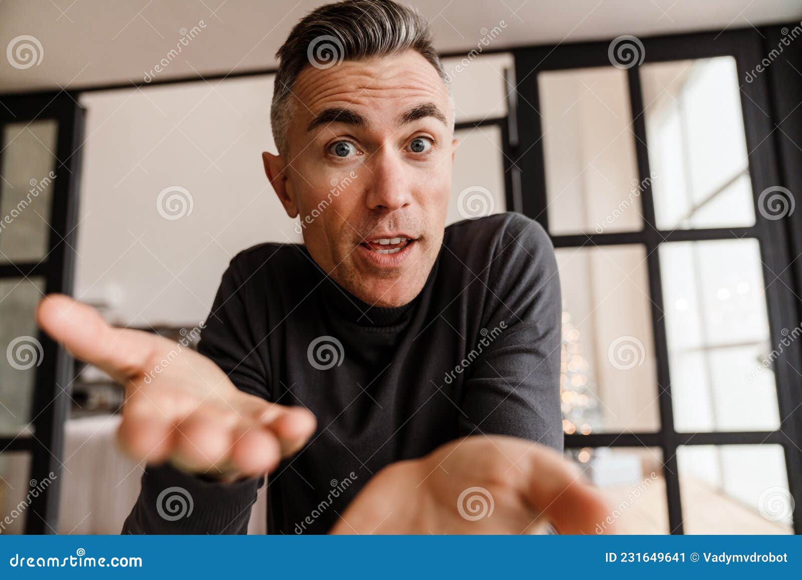 Surprised Man Gesturing and Looking at Camera while Sitting at Table ...