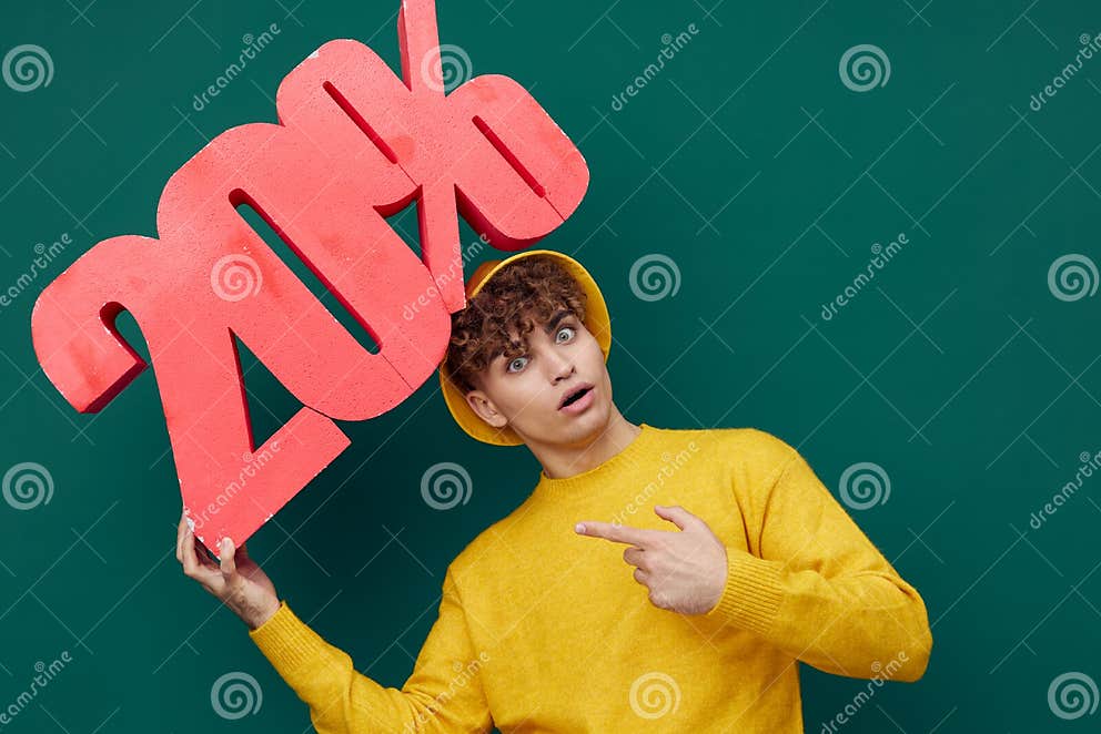 A Surprised Shocked Man Stands On A Green Background In Bright Clothes
