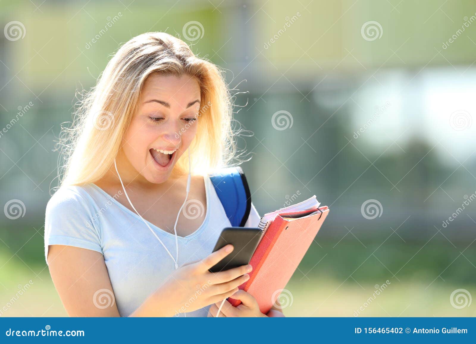 Surprised Student Checking Phone Messages in a Campus Stock Photo ...