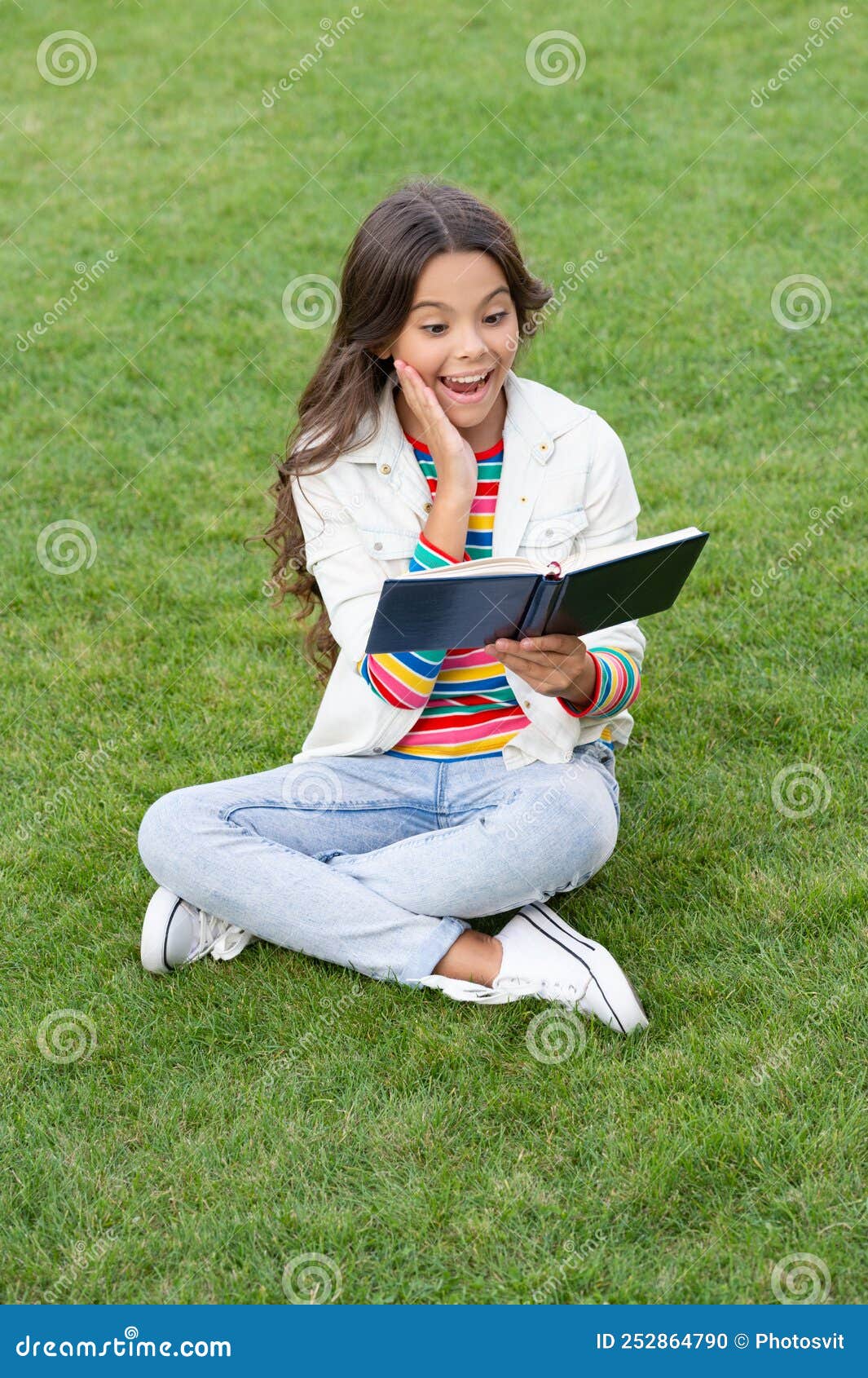 Surprised Teen Girl Read Book Sitting On Grass Reading Book Stock
