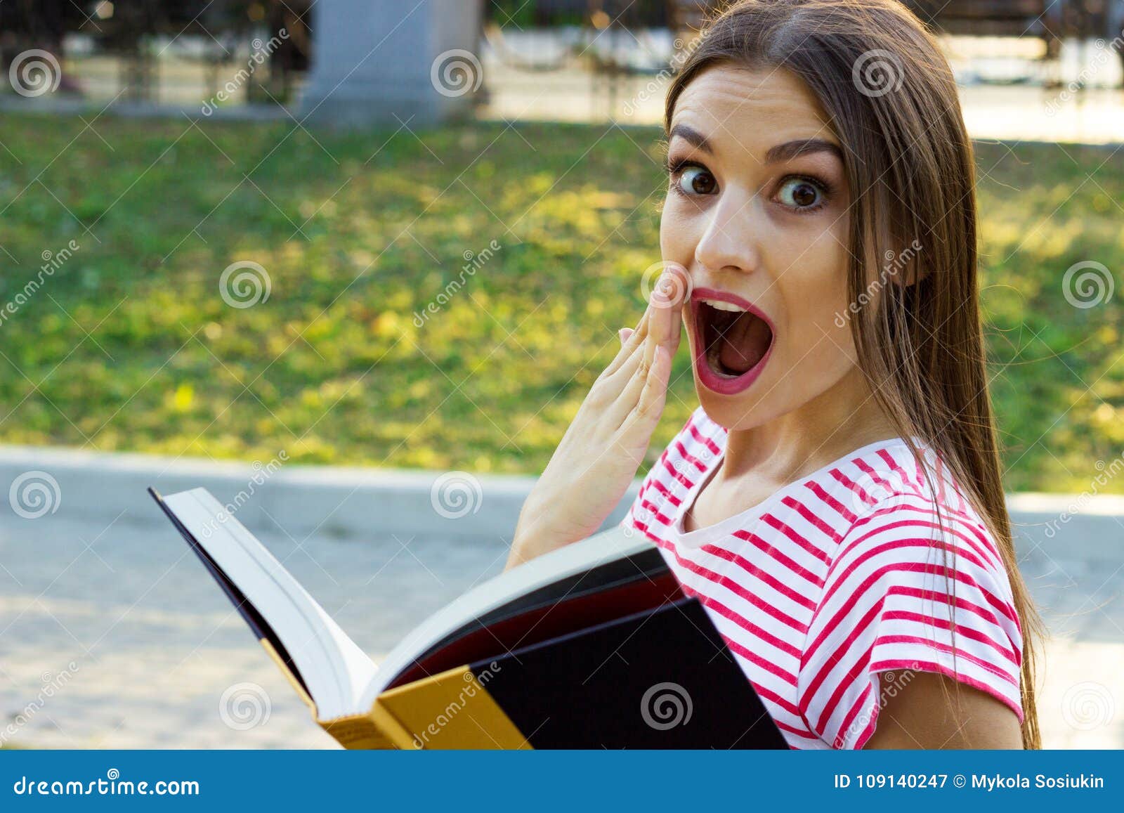 Surprised Young Girl Reading a Book Outside Stock Image - Image of ...