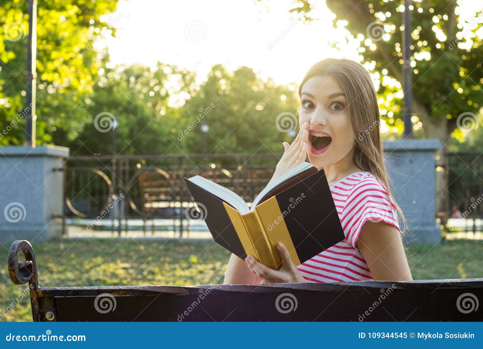 Surprised Young Girl Reading a Book Outside Stock Image - Image of ...