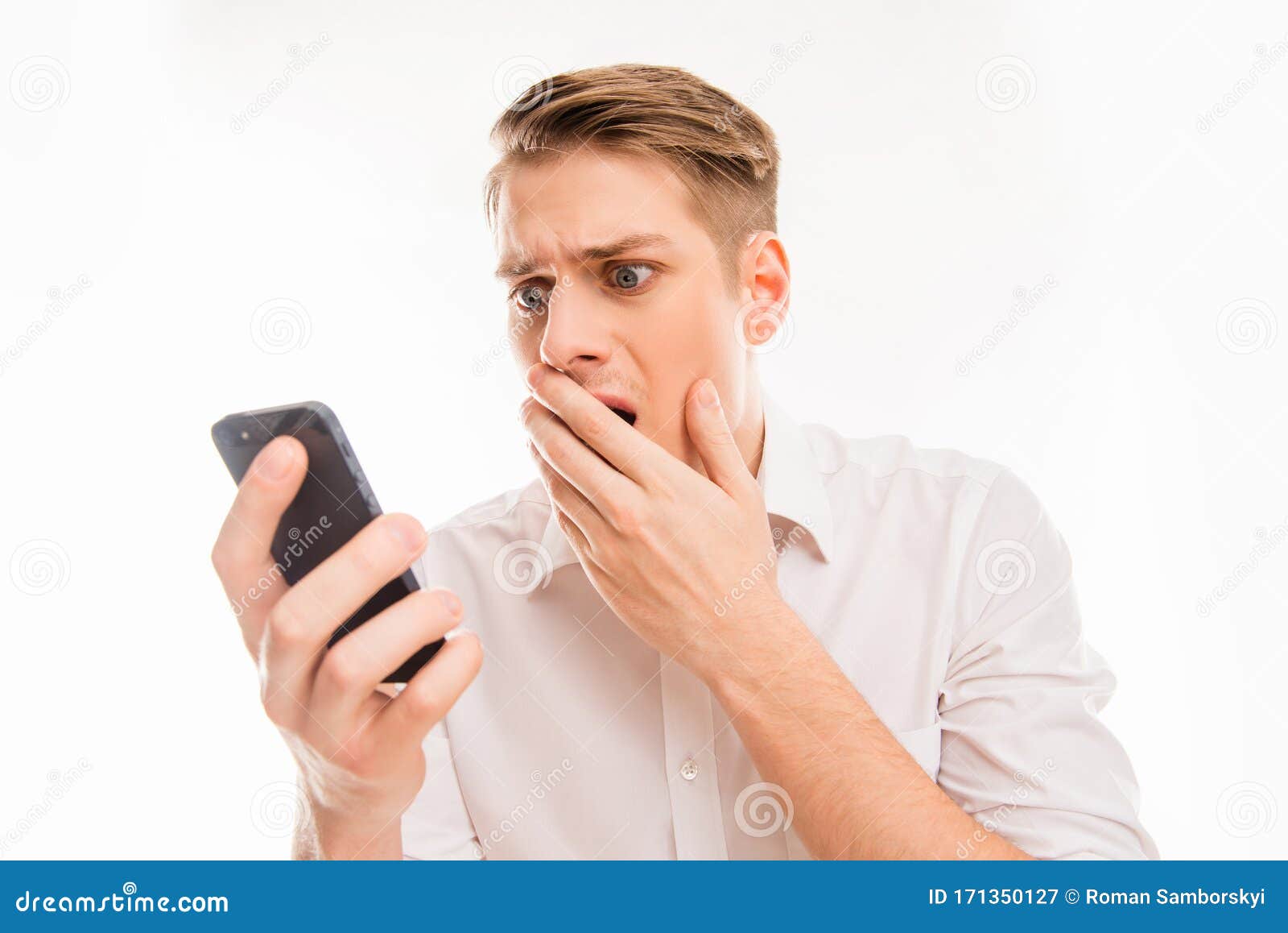 Surprised Young Man Holding Phone and Reading Message Covering M Stock ... Surprised Young Man Holding Phone and Reading Message Covering M Stock ...