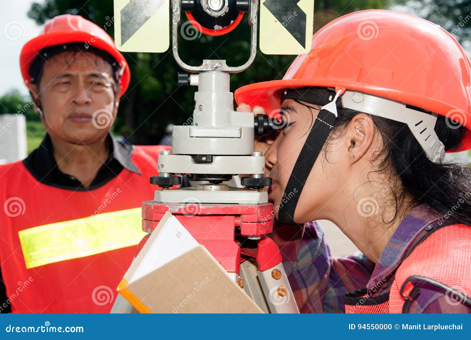 Surveyor or Engineer Setting Prism Reflector with Partner on the Field ...