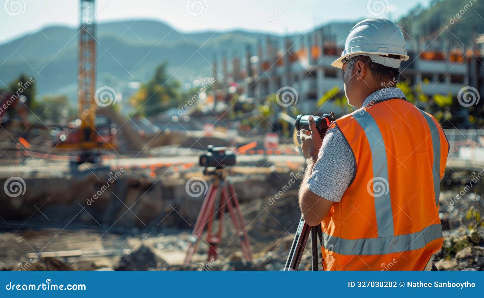 Surveyor in Safety Gear Using Equipment on a Construction Site with ...