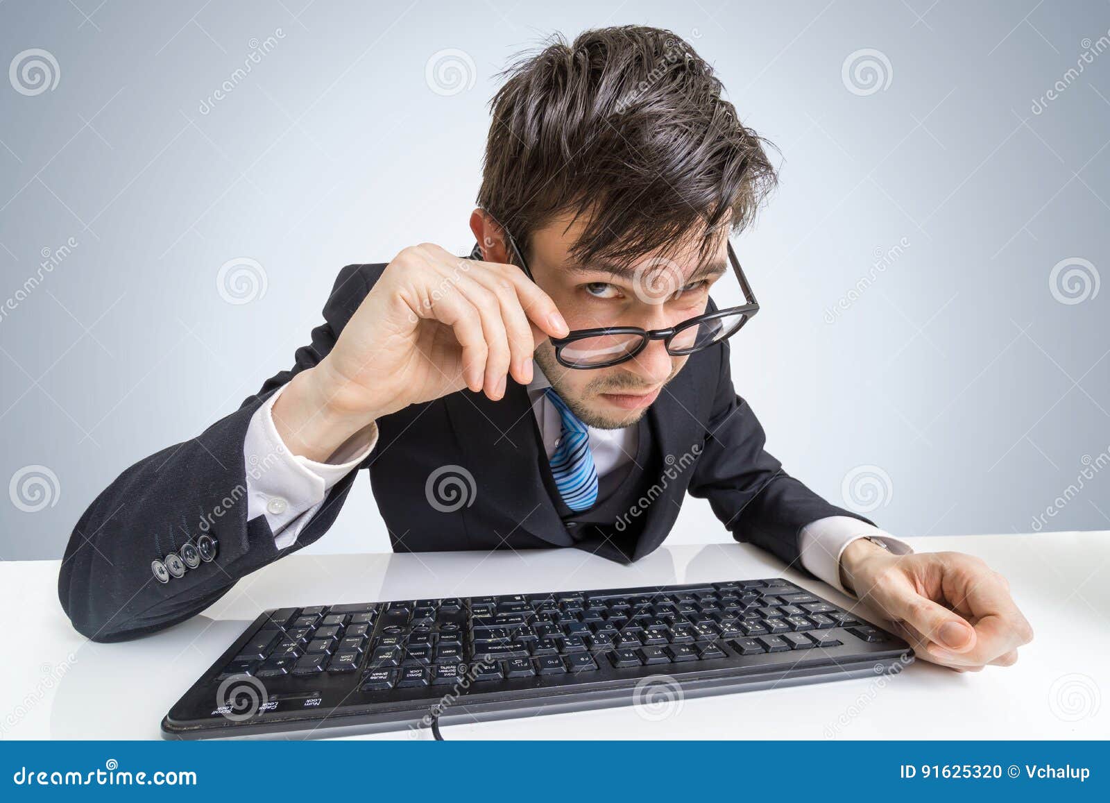 Suspicious Man in Glasses is Working with Computer and Looking at You ...