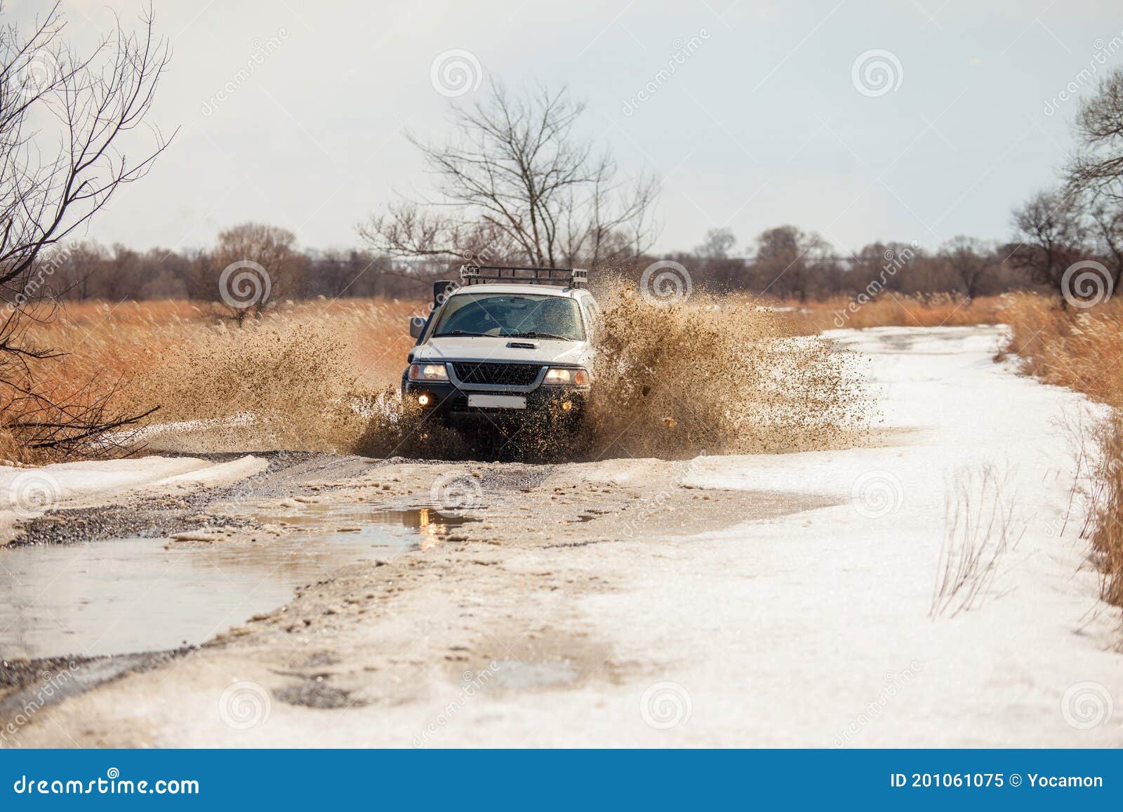 SUV on Dirt Road in Early Spring Making Splashes from a Puddle Stock ...