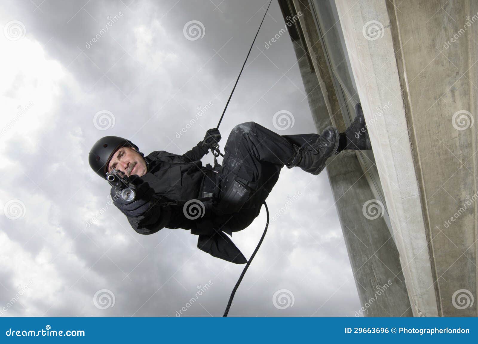 SWAT Team Officer Aiming Gun while Rappelling Stock Photo - Image of ...