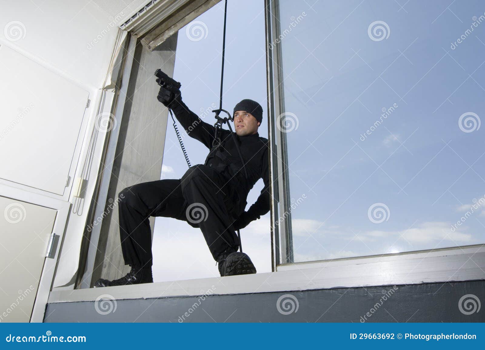 SWAT Team Officer Hanging from Window Stock Photo - Image of abseiler ...