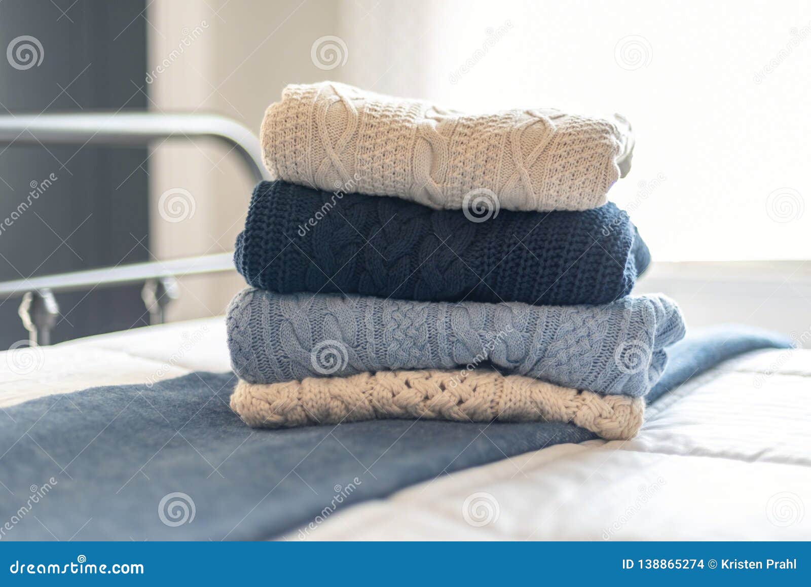 Sweaters folded on the bed stock photo. Image of collection - 138865274