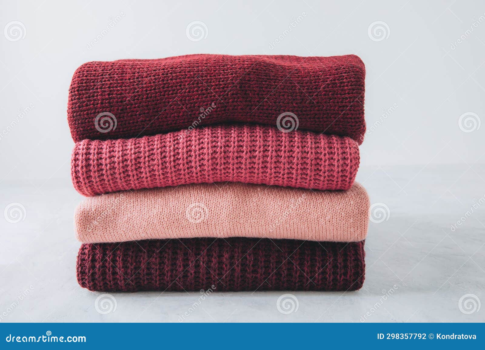 Sweaters. Red, Pink Sweaters Stacked on Gray Background Stock Photo ...