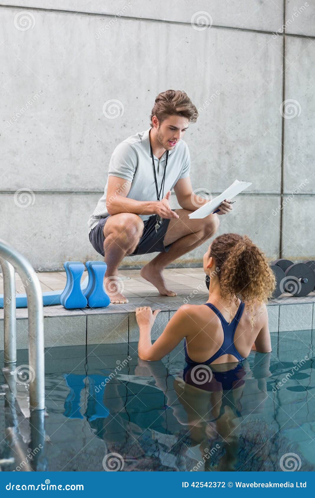 Swimmer Talking To Her Coach Poolside Stock Photo - Image of swimwear ...