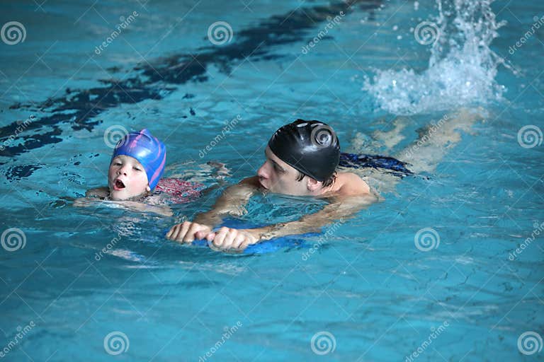Swimming Lesson - Child Practicing Flutter Kick with Kick Board with ...