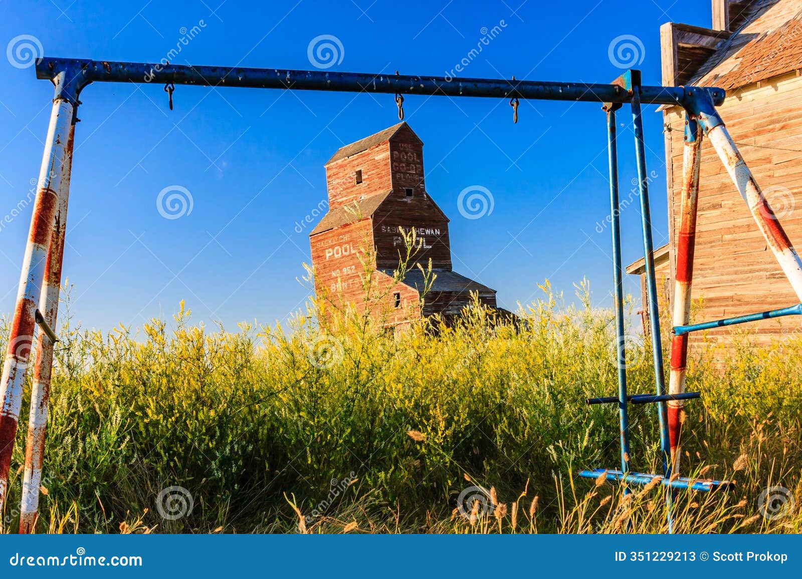 A Swing Set is Hanging from a Building with a Large Grain Silo in the ...