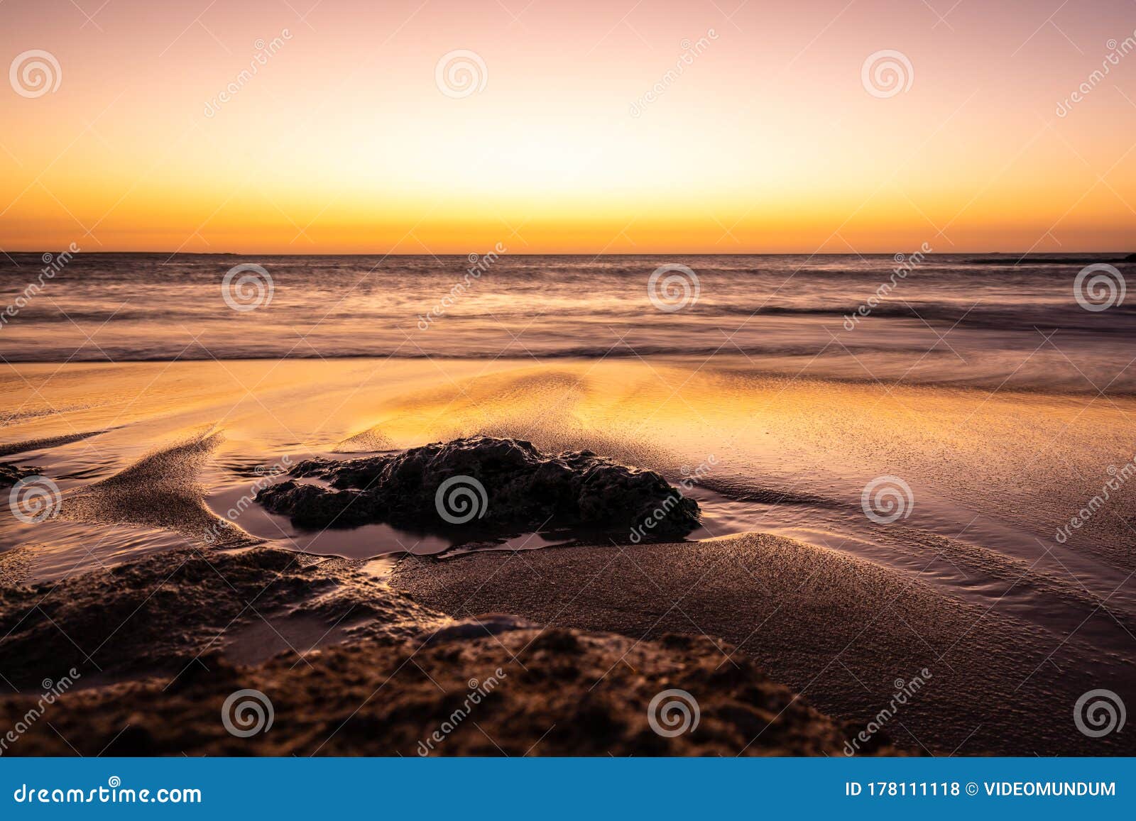 Swirl Pattern of a Waves Rolling Onto Beach at Sunset Time Stock Photo ...