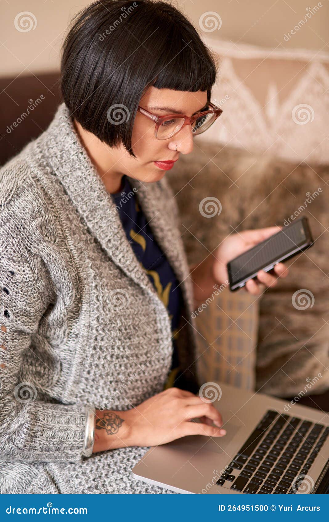 Syncing Her Data Wirelessly. a Young Woman Sitting on a Sofa Using a ...