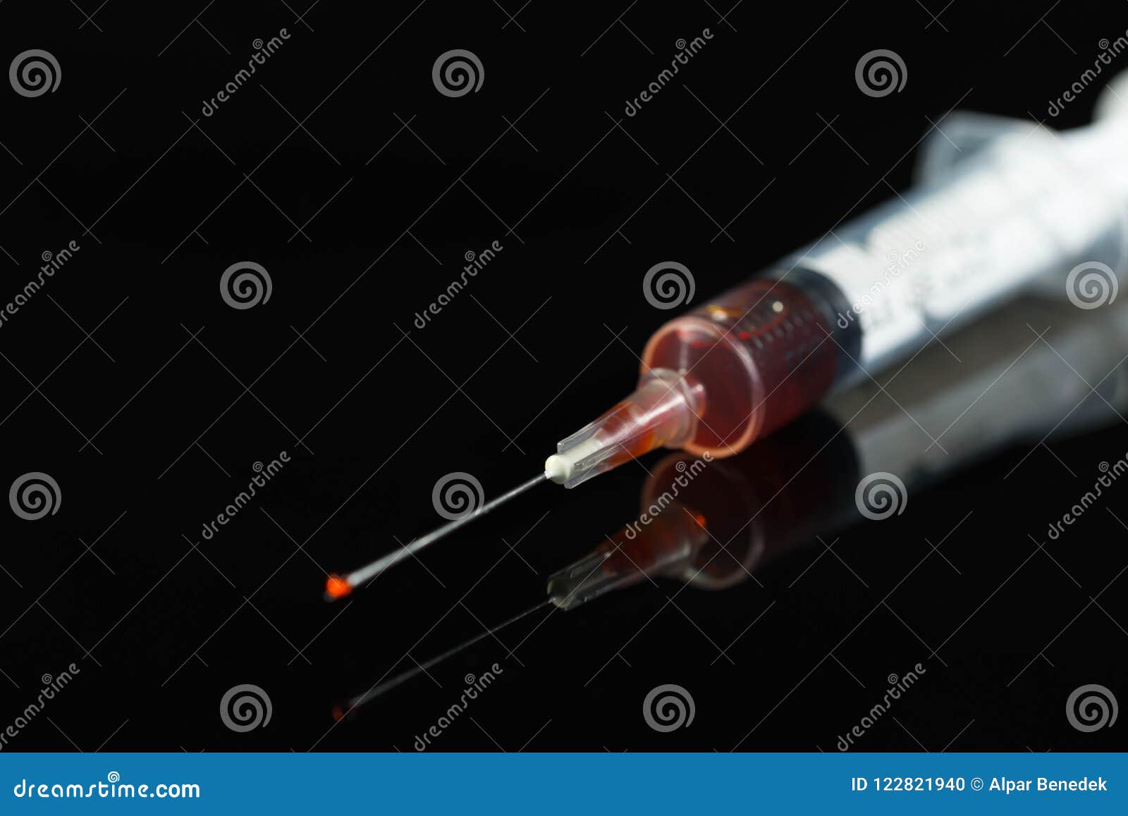 Syringe Filled with Red Liquid on Shiny Dark Surface Stock Photo ...