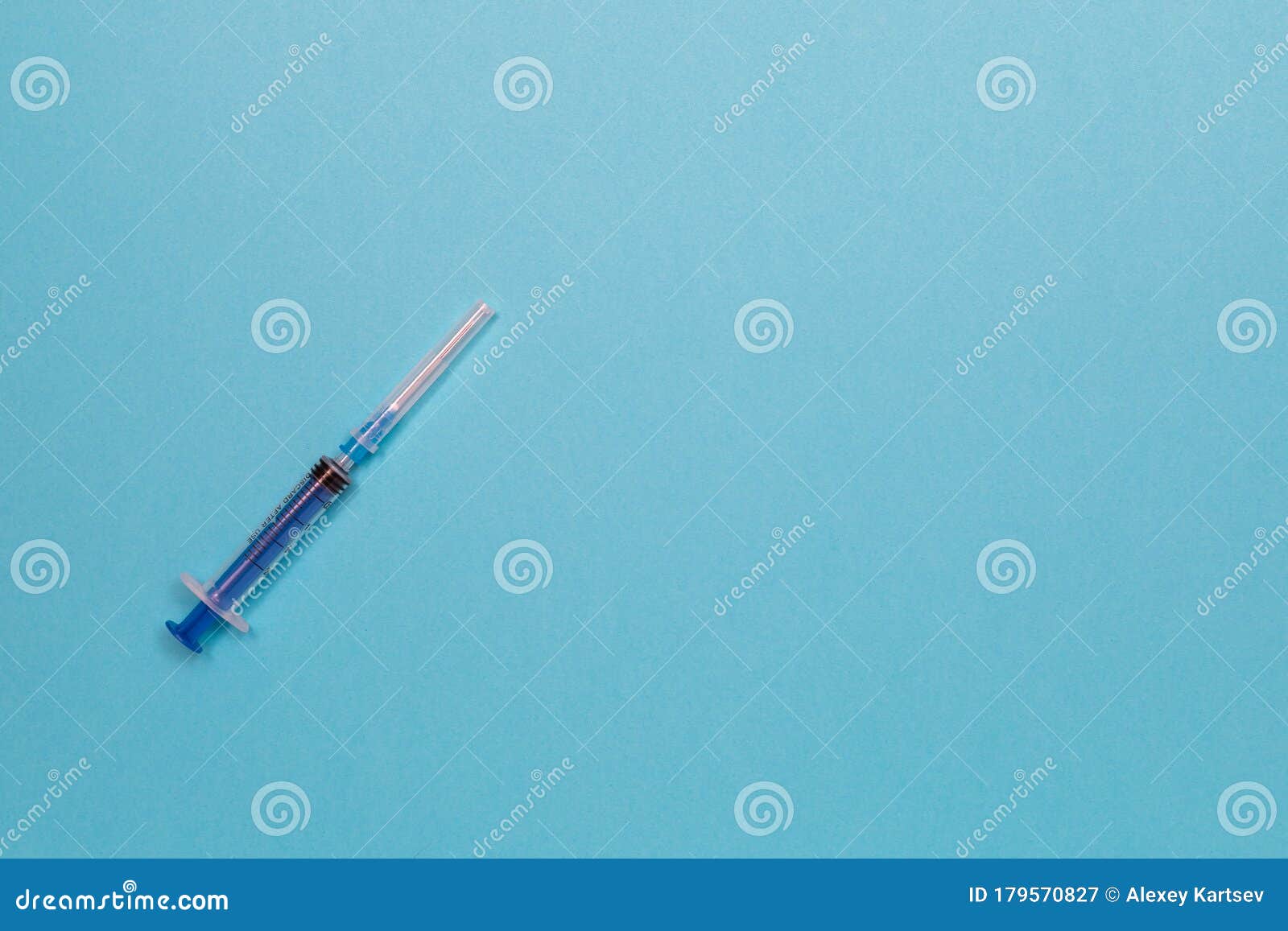 Syringe for Injection with a Needle on a Blue Background. Top View with ...