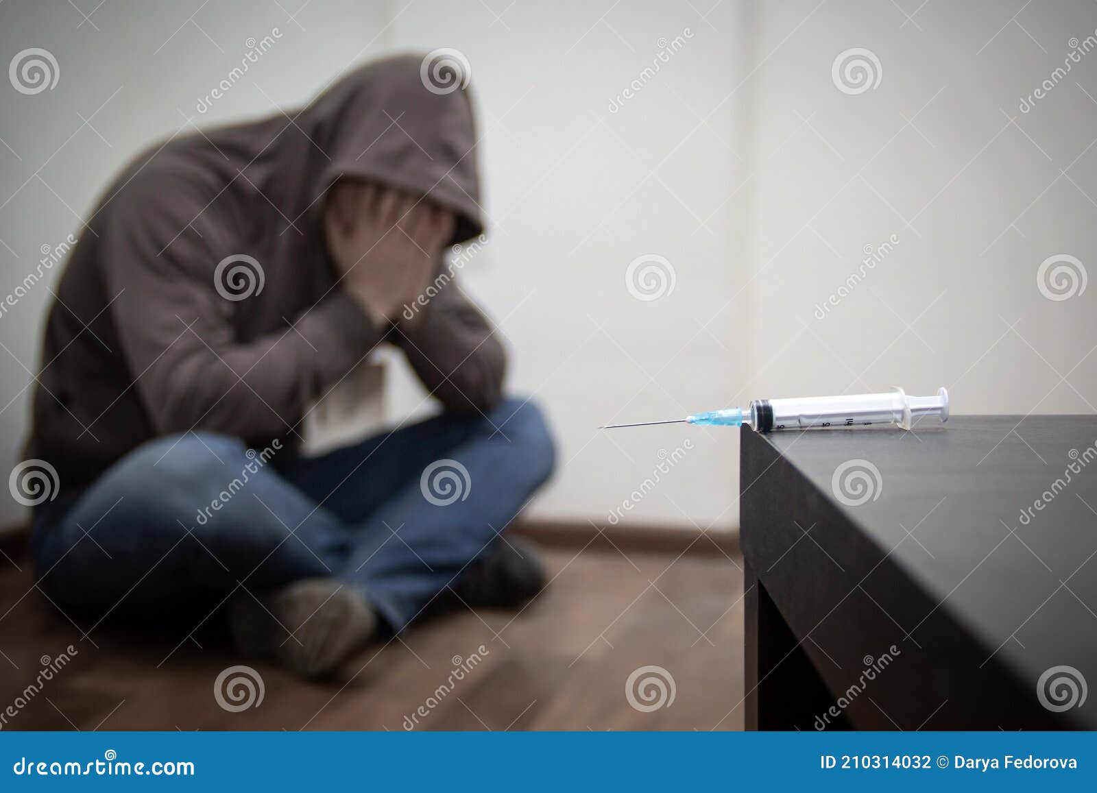 Syringe and Man Drug Addict without of Focus Sitting in Corner in the ...