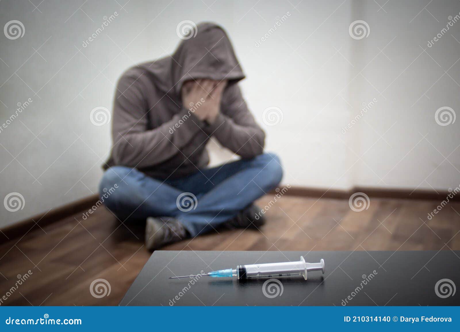 Syringe and Man Drug Addict without of Focus Sitting in Corner in the ...