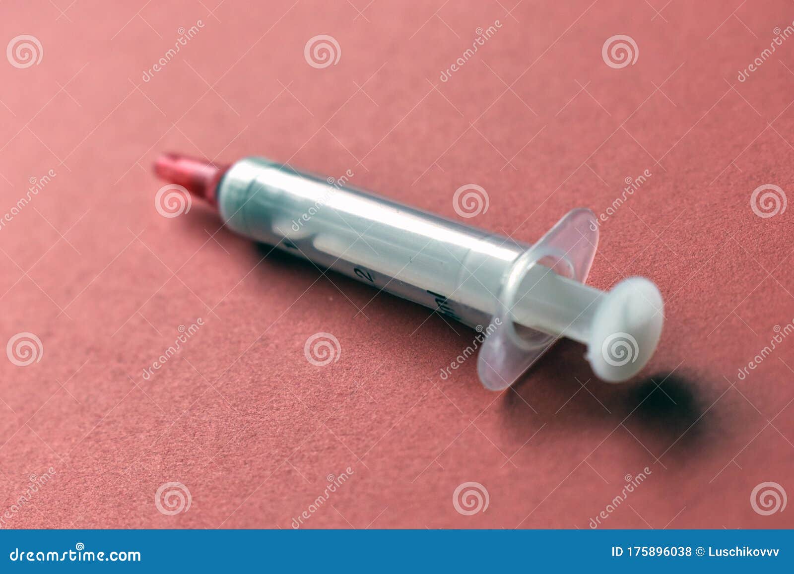 Syringe on a Red Background with Thermal Paste for the Processor Inside ...