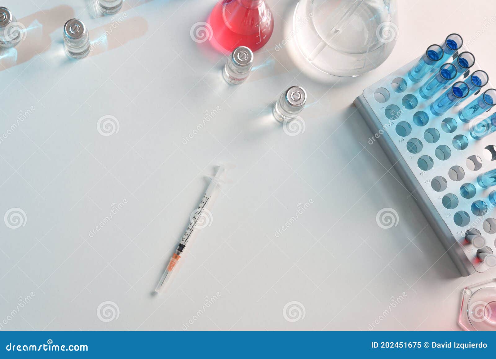 Syringe on Table in Pharmaceutical Laboratory with Vials and Glassware ...