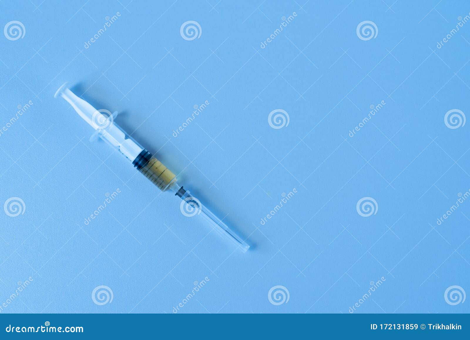 Syringe with Yellow Liquid on a Blue Background. Stock Image - Image of ...