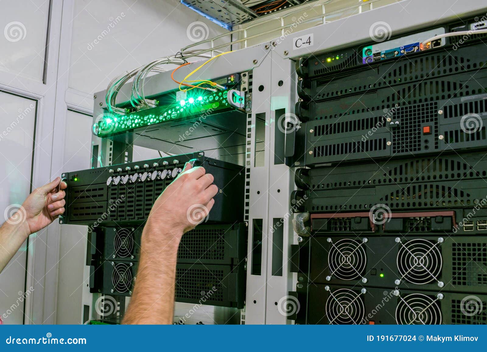 System Engineer Installs a New Server in a Rack with Computer Equipment ...