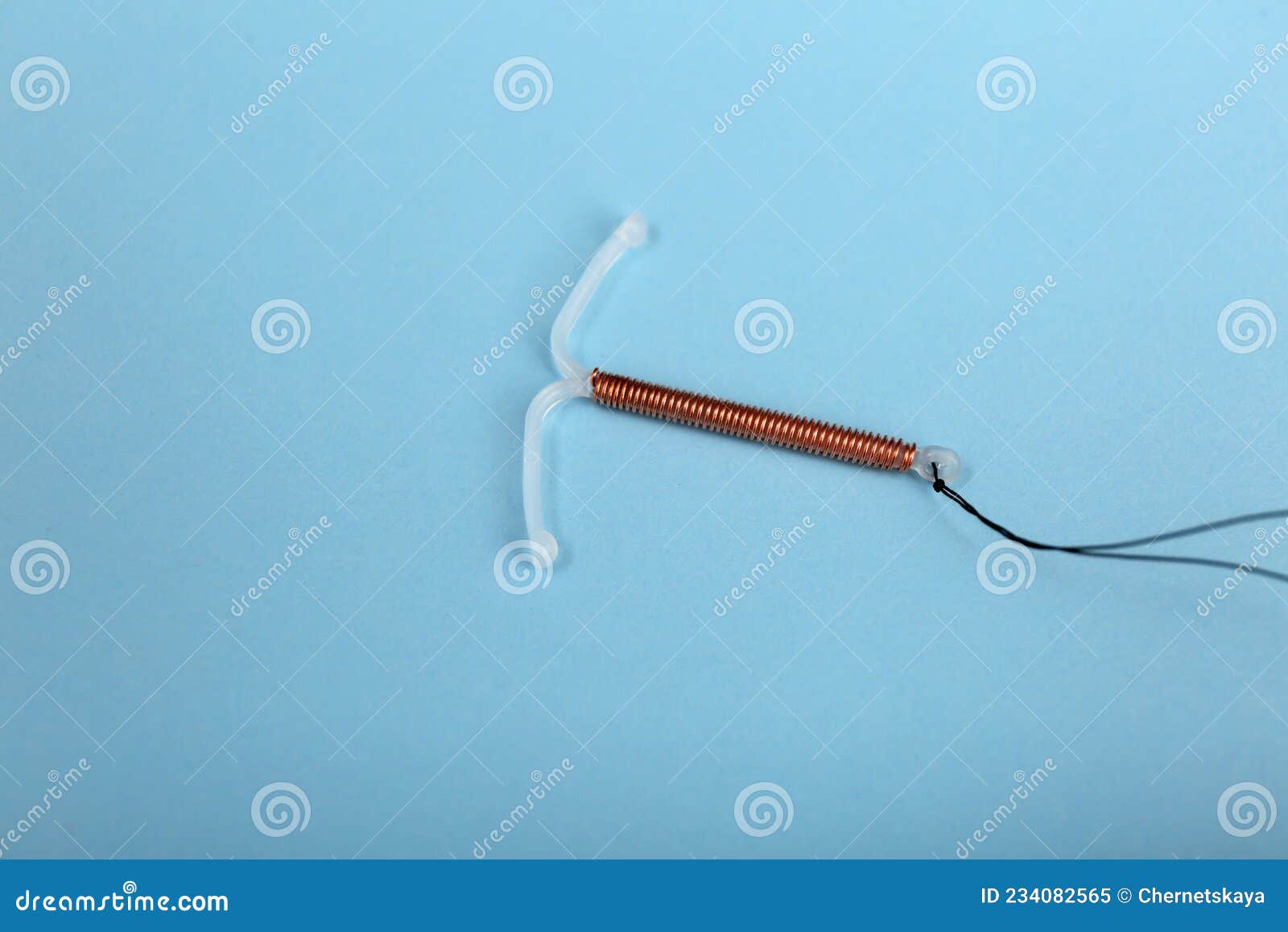 T Shaped Intrauterine Birth Control Device On Light Blue Background