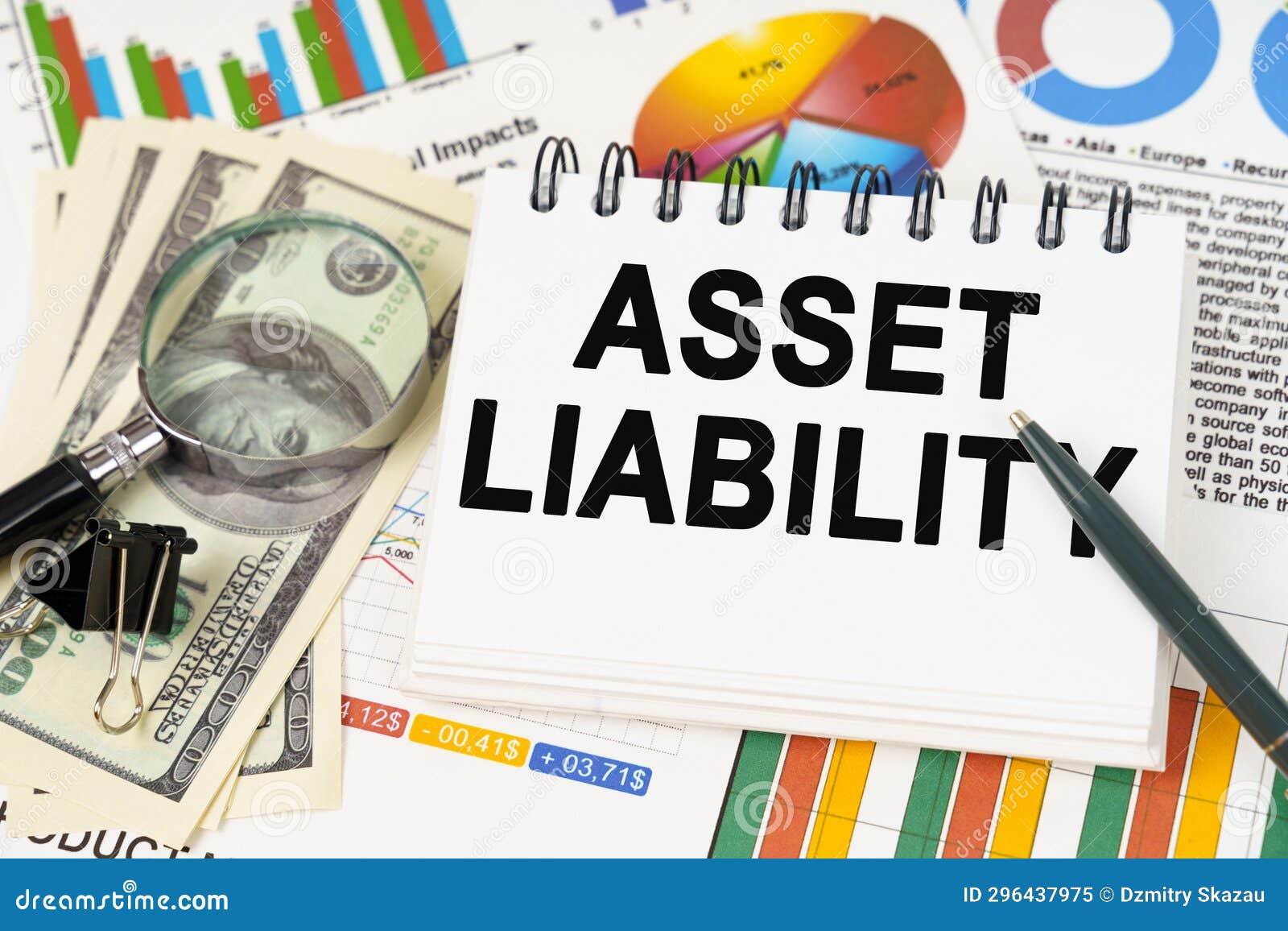 On the Table are Business Charts, Dollars and a Notepad with the ...