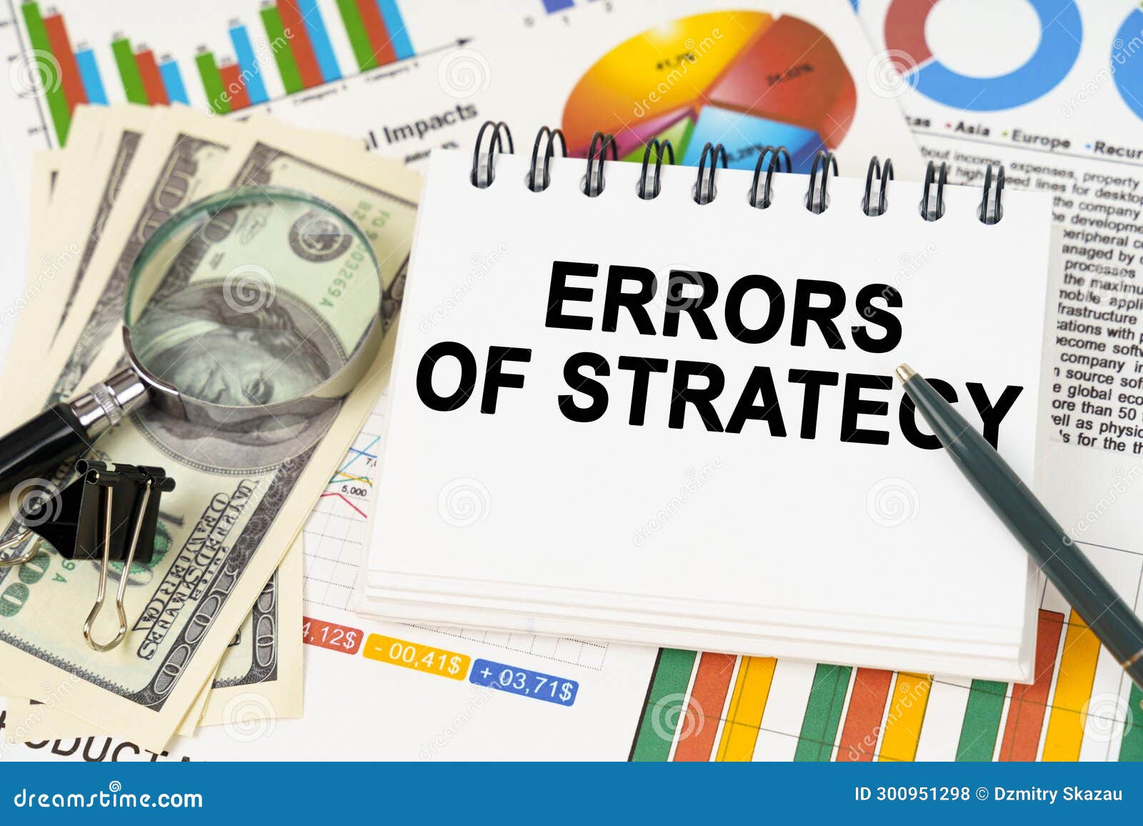 On the Table are Business Charts, Dollars and a Notepad with the ...