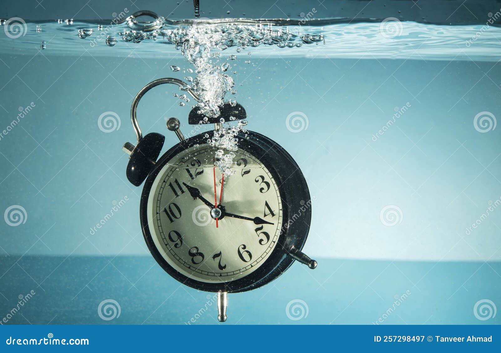 Table Clock Sinking into Blue Water Tank - Concept of Time Management ...