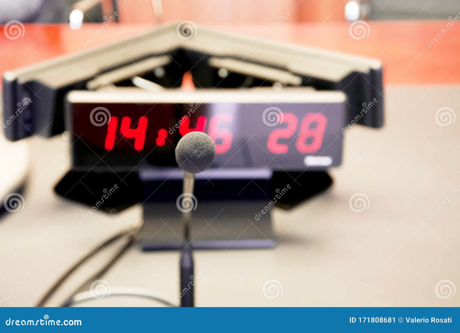 A Table Microphone on the Wooden Table of a Board in Front of a Digital ...