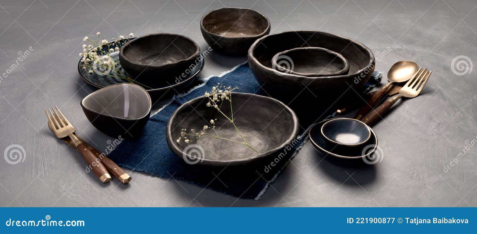 Table Setting with a Black and Blue Plates on Gray Background ...