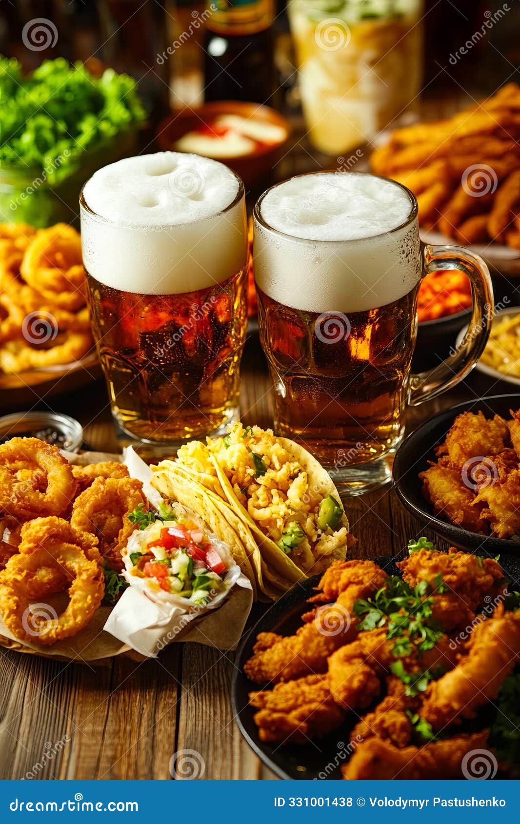 A Table Topped with Plates of Food and Two Glasses of Beer Stock Photo ...