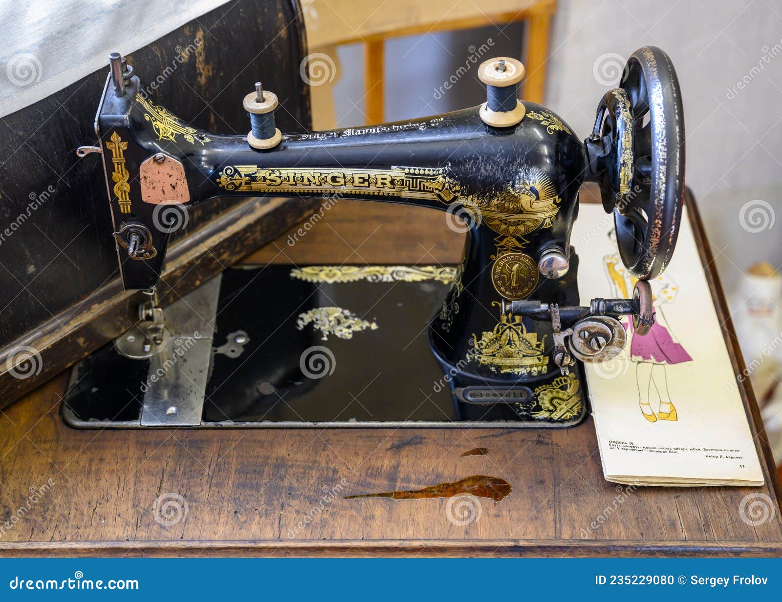 A Table with a Vintage German Hand Sewing Machine and a Sewing Magazine ...